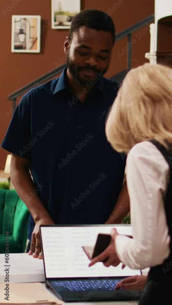 Vertical video Travellers giving passports at reception, using id ...