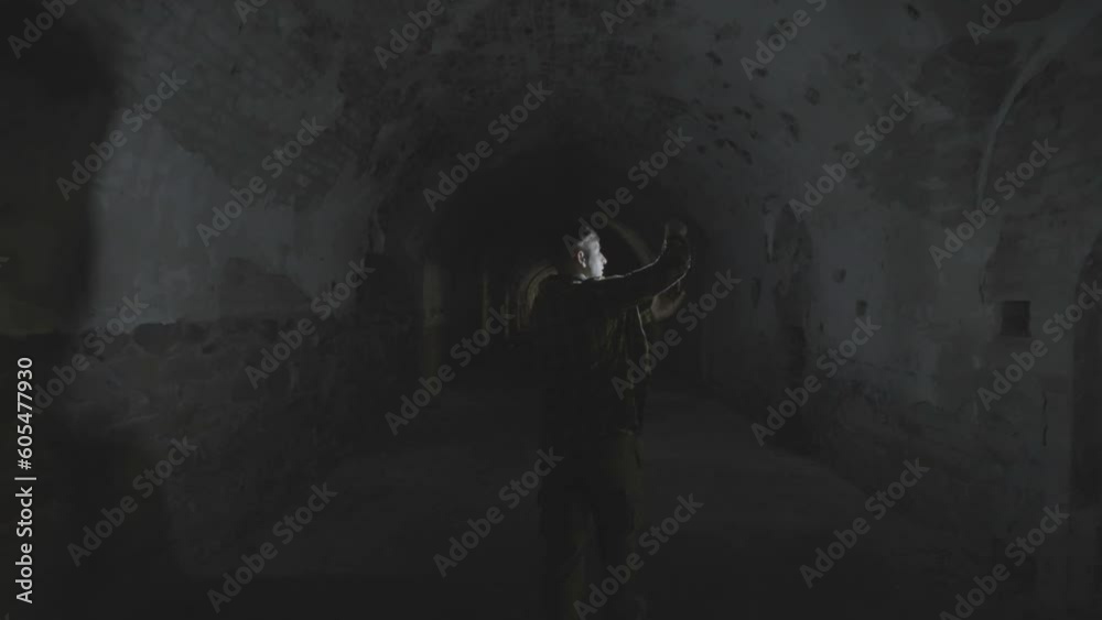 A man in a dungeon, holding a lamp. Exploring catacombs or old tunnels ...