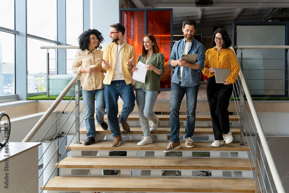 Group of successful office employees going down the stairs for a coffee ...