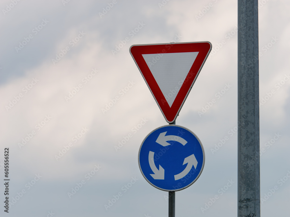 Close-up photo of a yield and roundabout traffic sign attached to a ...