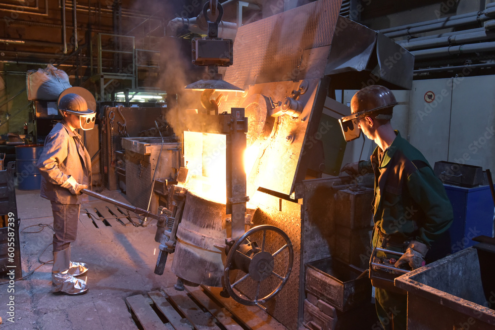 workers in a foundry casting a metal workpiece - safety at work and ...