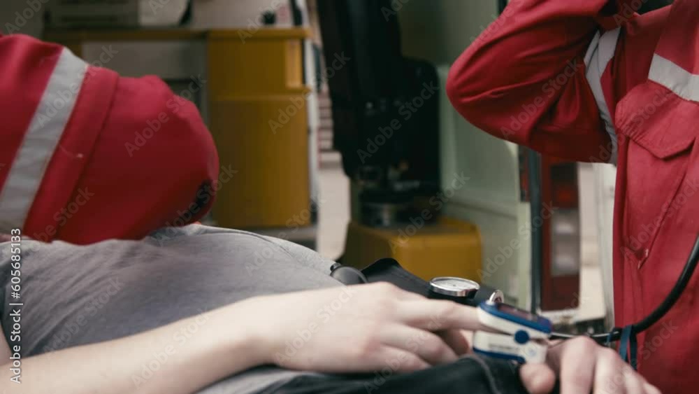 An EMS paramedic team provides medical care to an injured patient. A ...