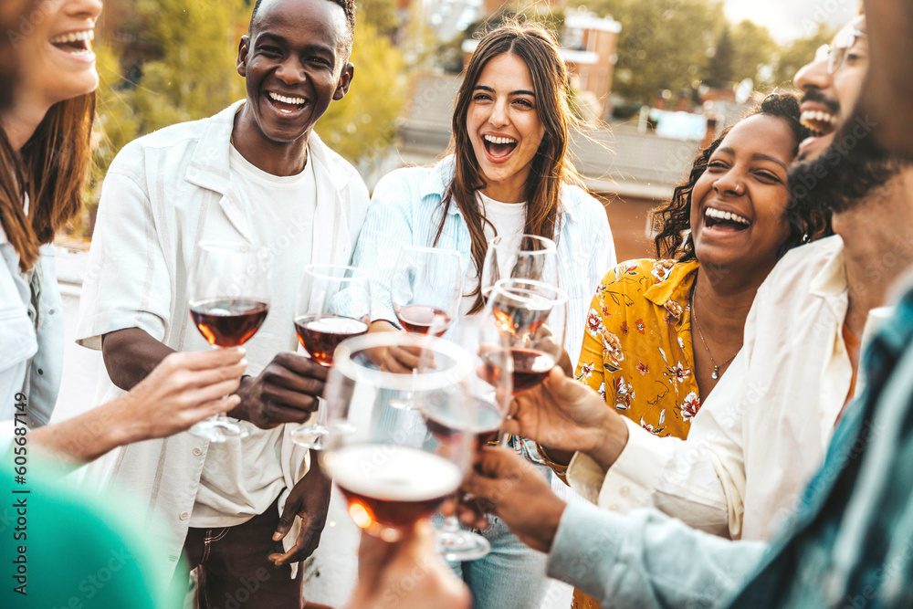 Multiracial friends celebrating rooftop party drinking red wine ...