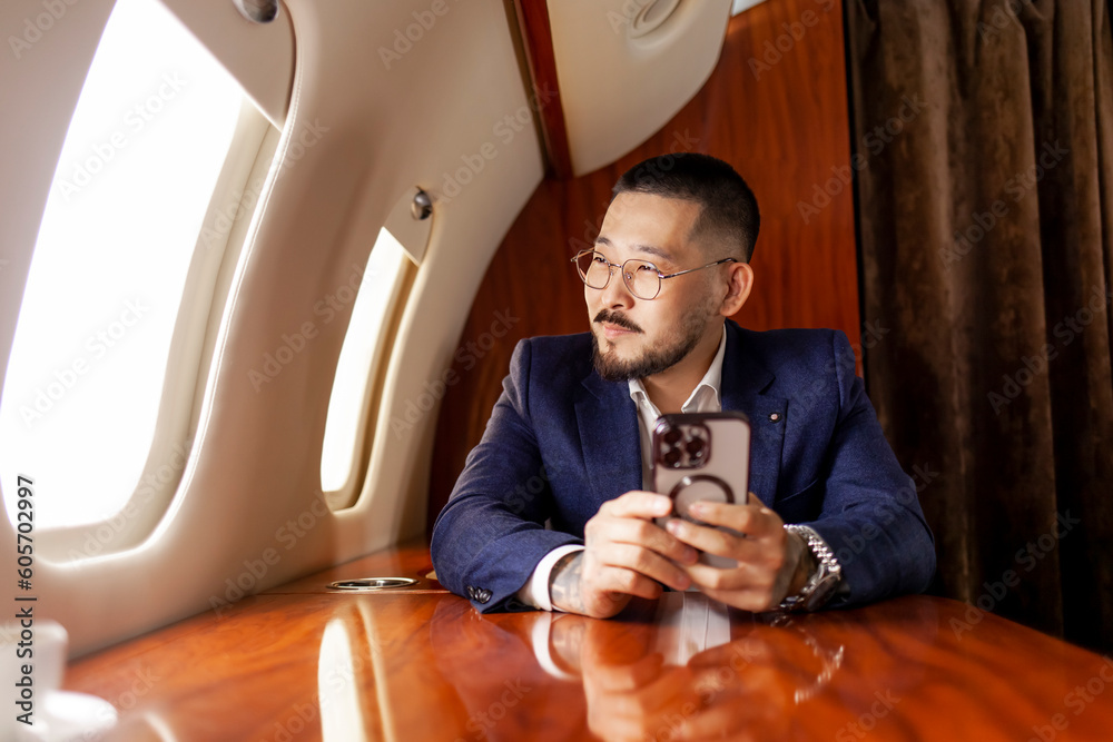 Asian successful businessman flies in private luxury jet and uses ...