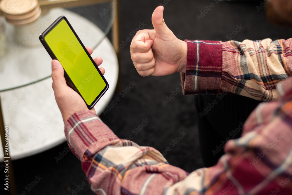 Person making like gesture front cell phone with chroma key, green ...