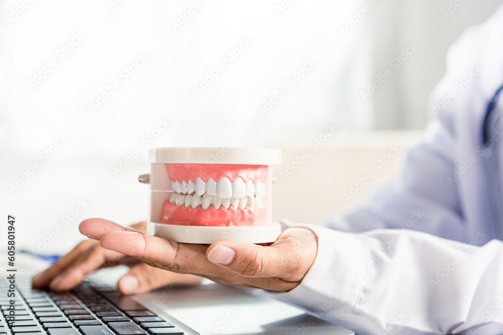 Oral dental hygiene. Female doctor sitting and hold tooth on desk at ...