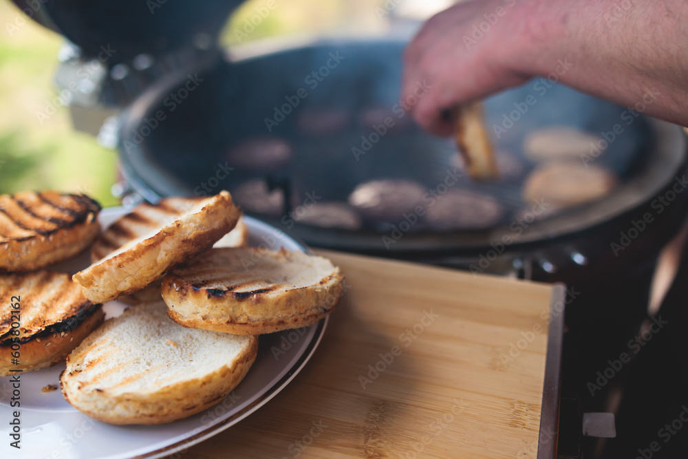 Process of cooking and grilling beef burgers on open-air street food ...