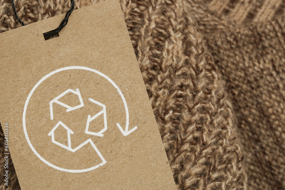 Close up of clothing tag with recycle icon. Recycling products concept ...
