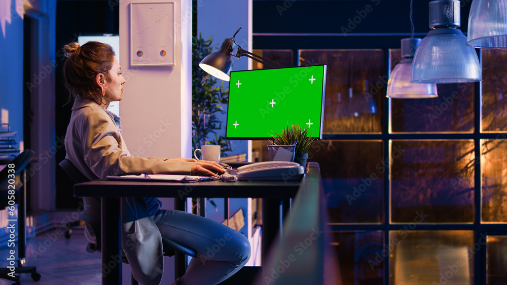Young entrepreneur using pc with green screen at night, working on ...