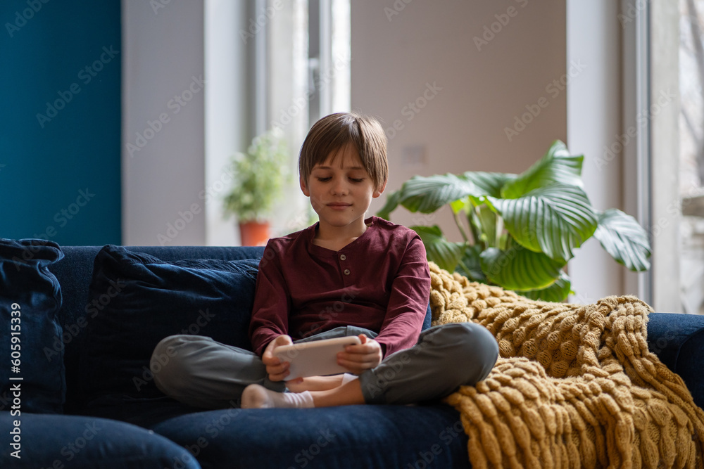 Little boy kid playing mobile games while resting at home, child ...