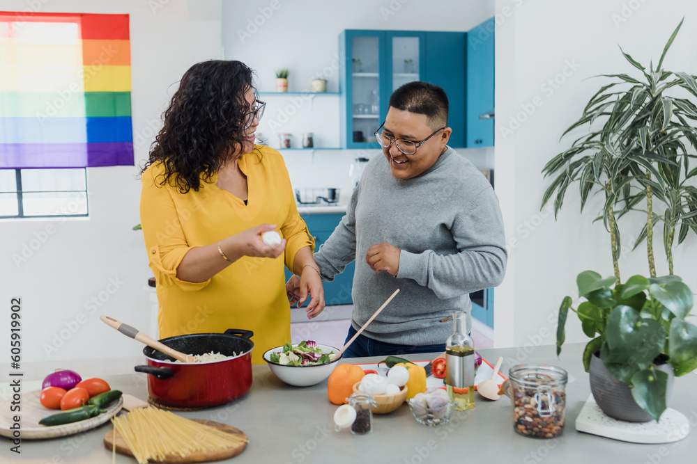 Foto de Latin lesbian couple cooking dinner in kitchen at home in ...