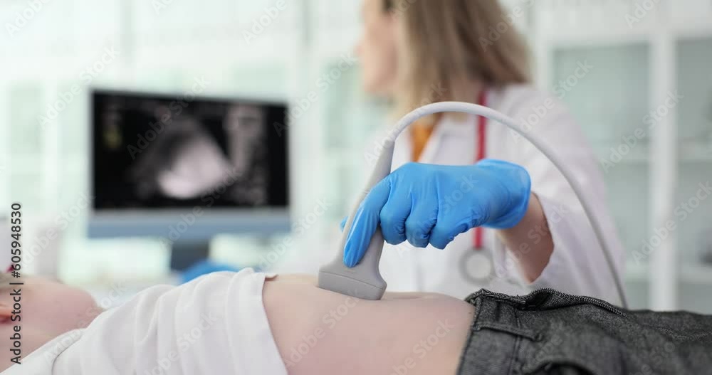 Attentive doctor checks child patient stomach with modern ultrasound ...