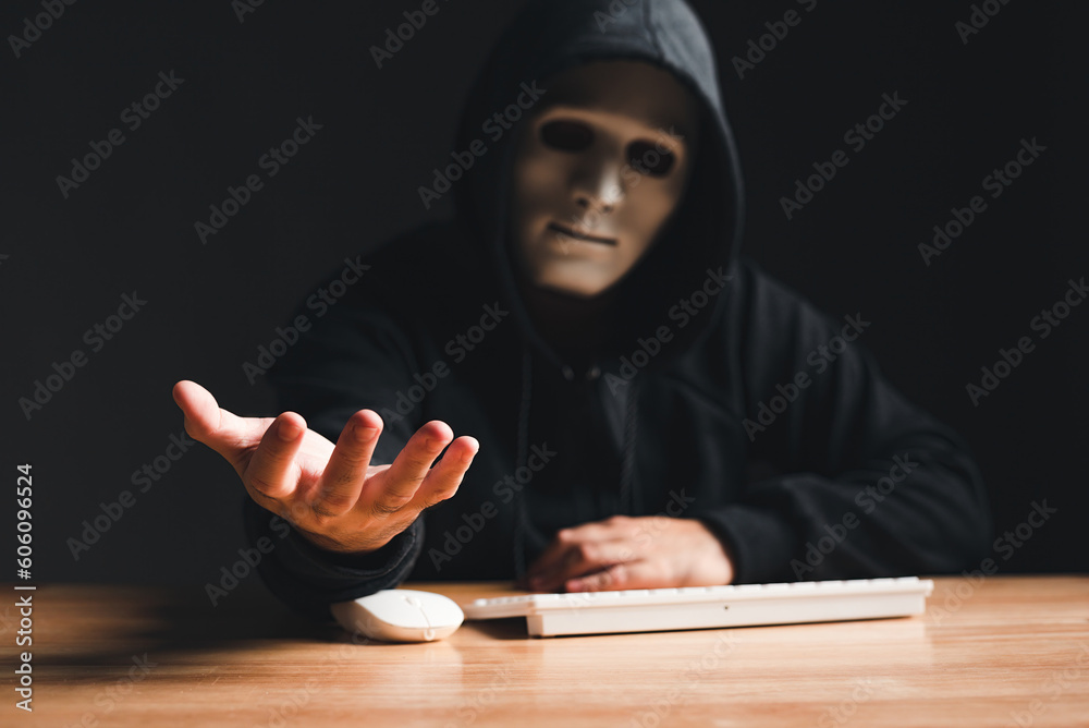 Black hat hacker force demands ransom by holding out his hand on table ...