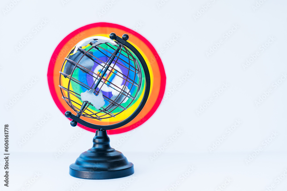 Metallic model of a globe with LGBT colorful rainbow background on the ...