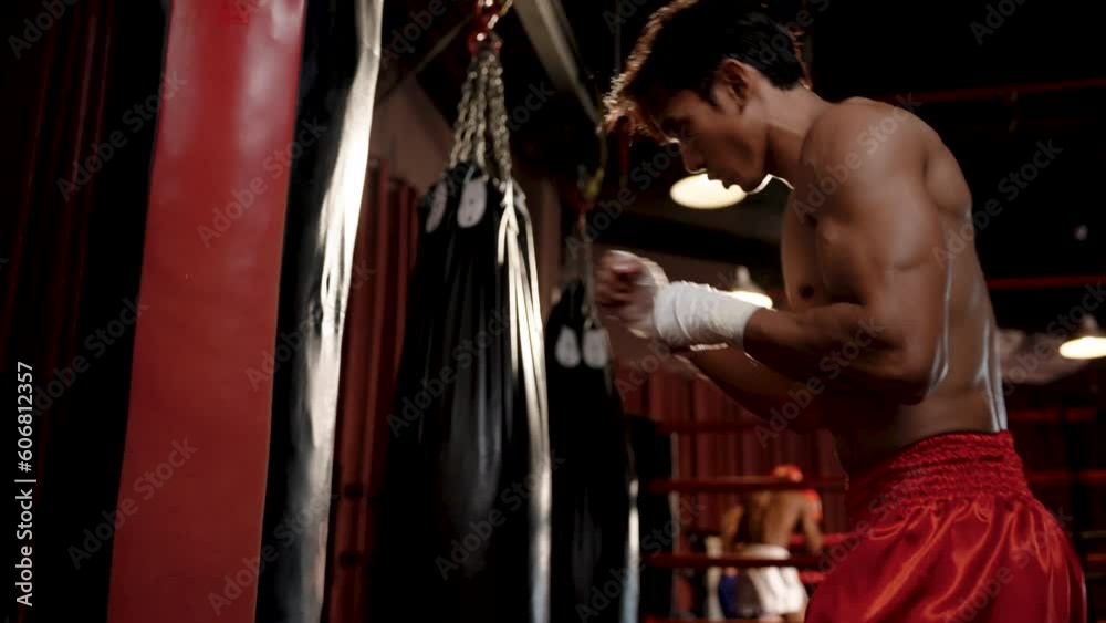 A strong Asian male boxer with big muscles. He takes off his shirt and ...