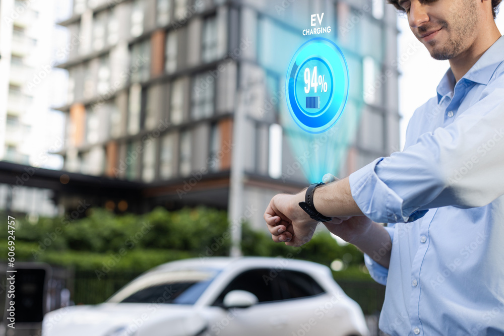 Progressive businessman check wearable hologram watch on electric car ...