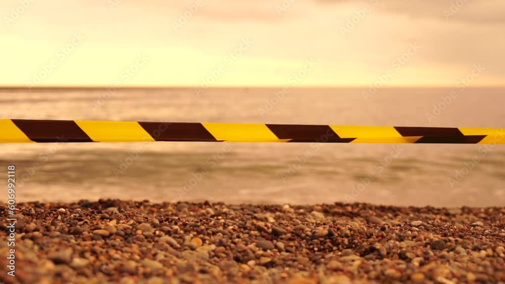 Yellow black warning tape barrier ribbon swinging in the wind across ...