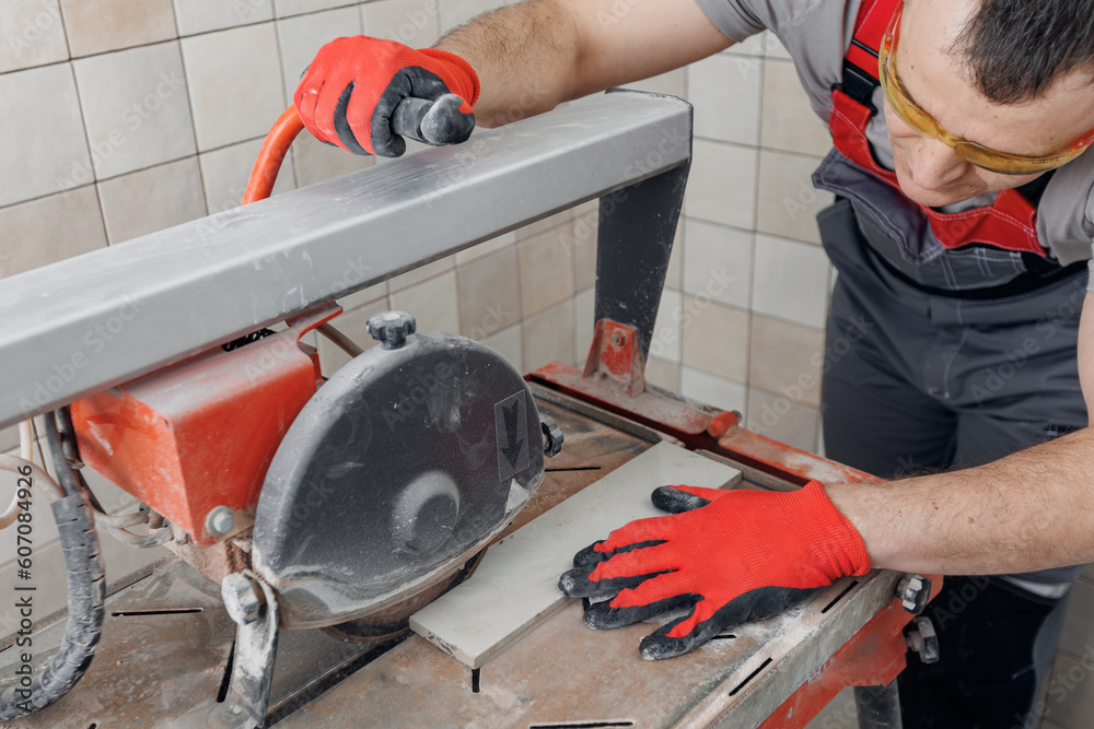 Tile cutting tile on wet saw machine, top view. Work tiler with cut ...
