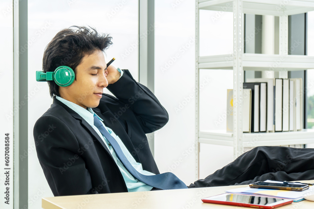 Happy businessman using headphones listen to music during break at ...