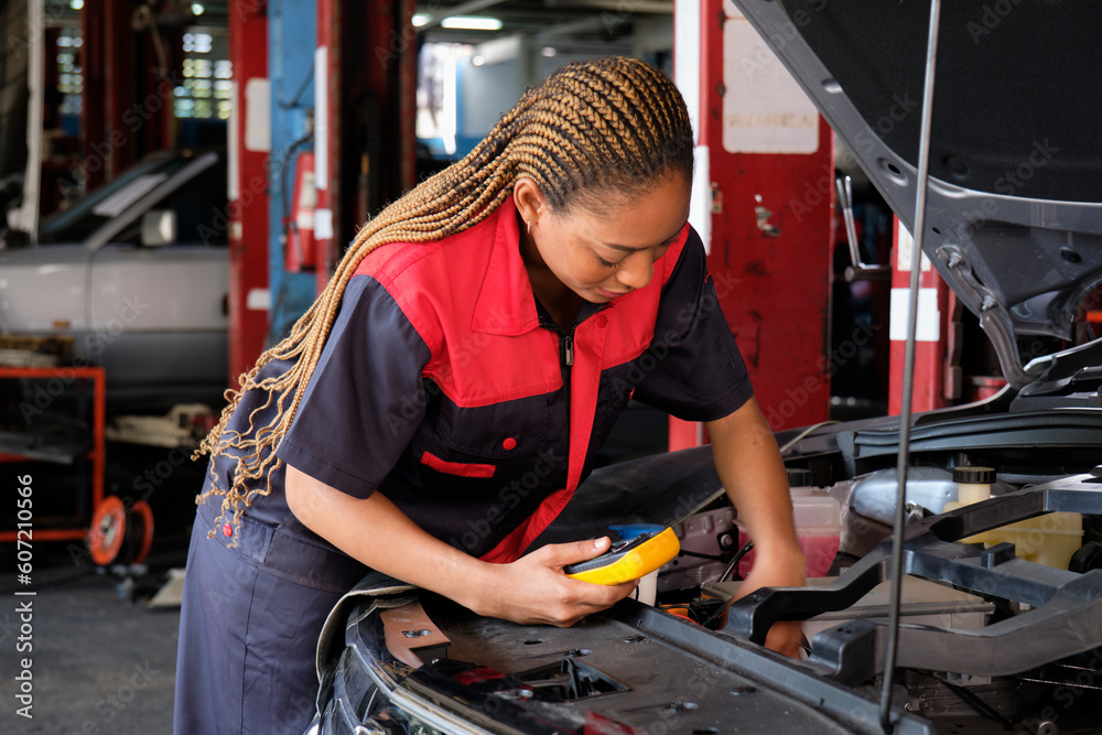 One Black female professional automotive mechanical worker checks an EV ...