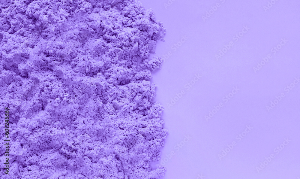 Violet kinetic sand on very peri color paper background with copy space ...
