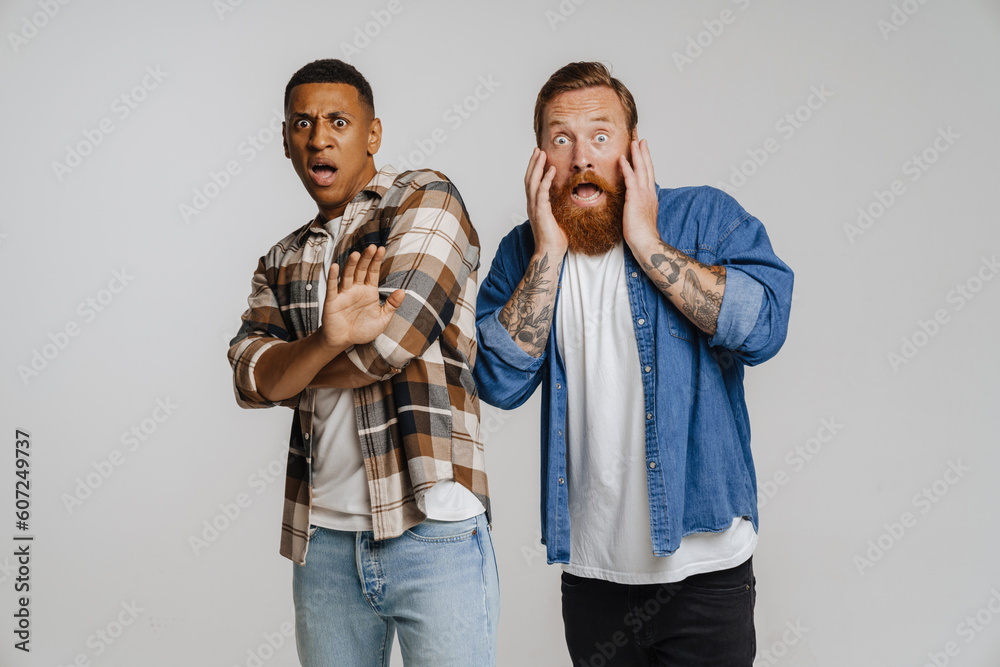 Two scared men grabbing head and expressing fear standing isolated ...
