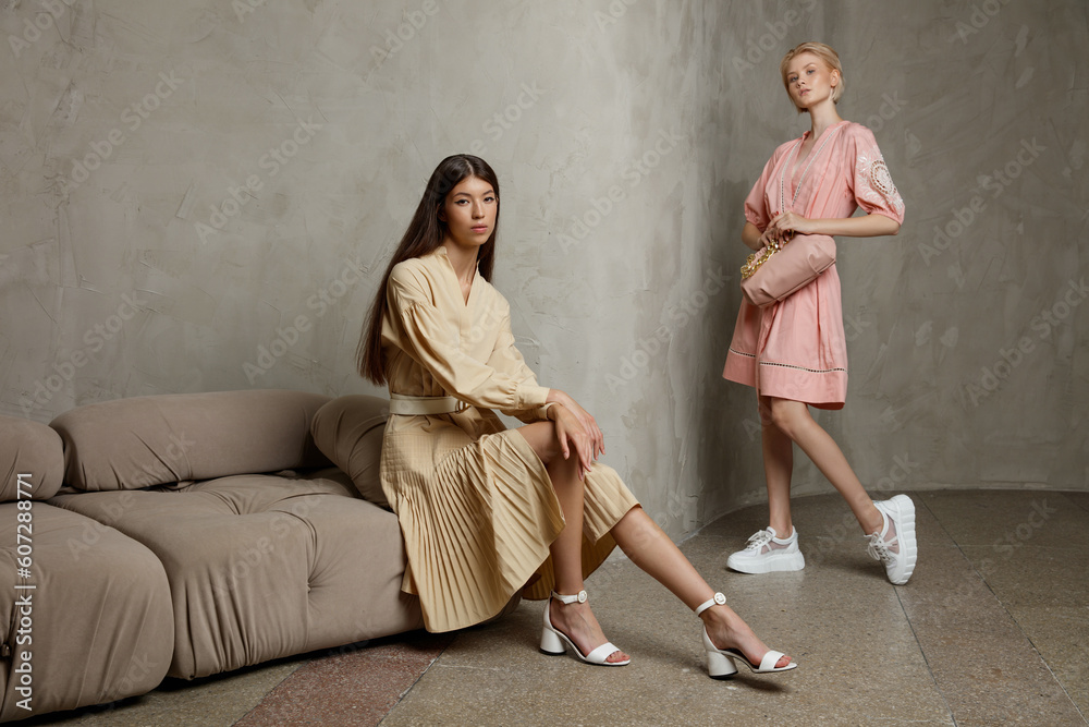 Two fashion models in summer looks, outfits. Pretty beige and peach ...