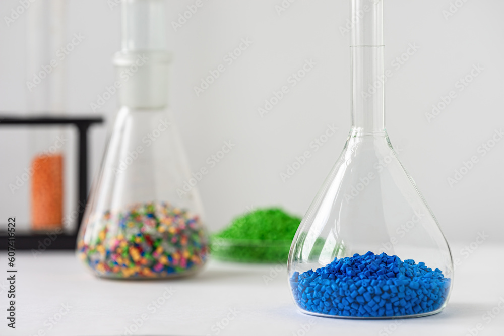Plastic factory laboratory. Glass flasks with colored dye in granules ...