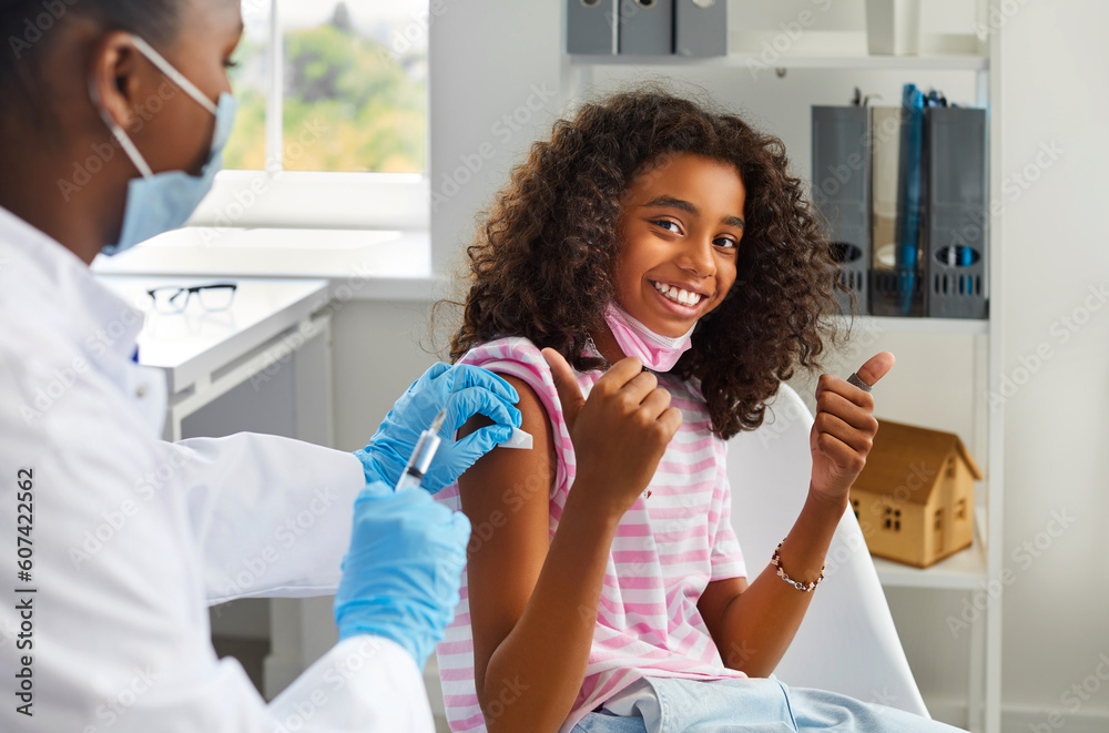 Childhood immunization. HHappy dark-skinned teenage girl showing thumbs ...