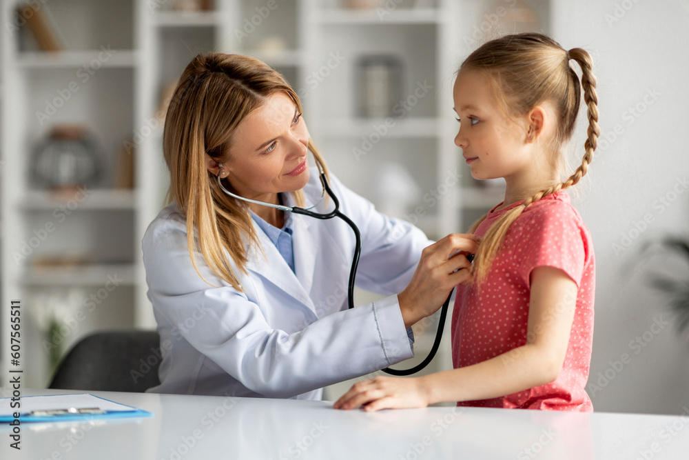 Female doctor checking lungs of little girl during medical checkup in ...