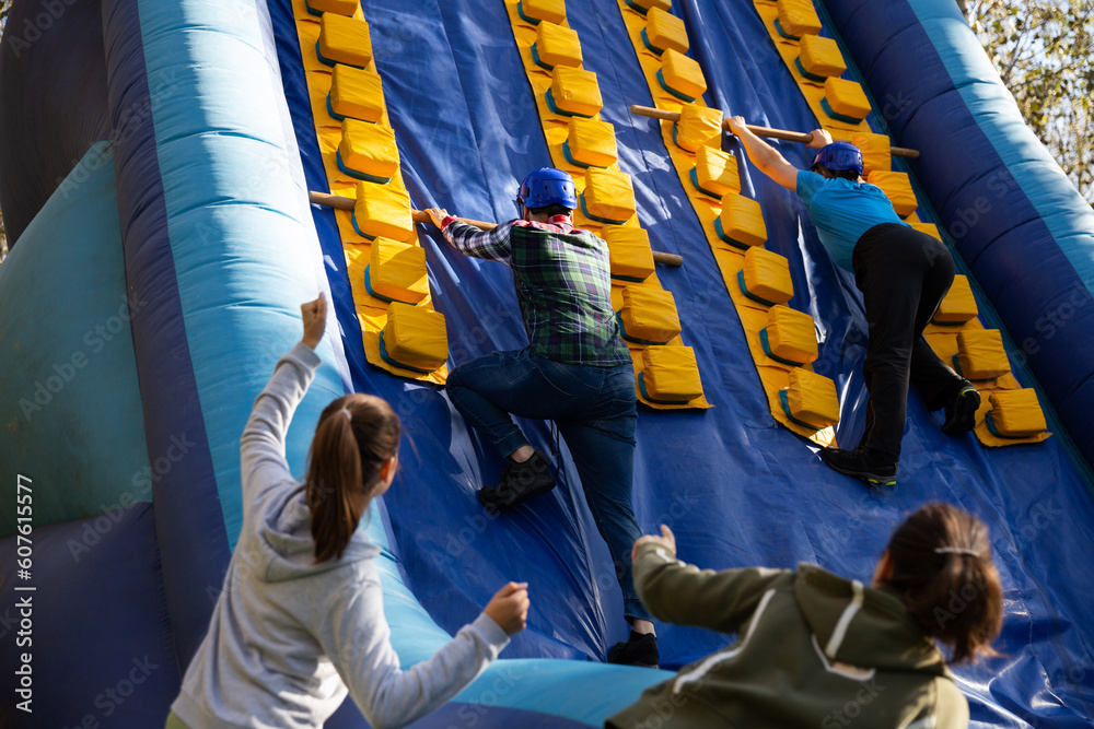 Excited male and female friends having fun passing obstacle course at ...