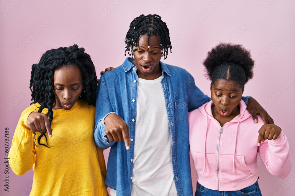 Group of three young black people standing together over pink ...