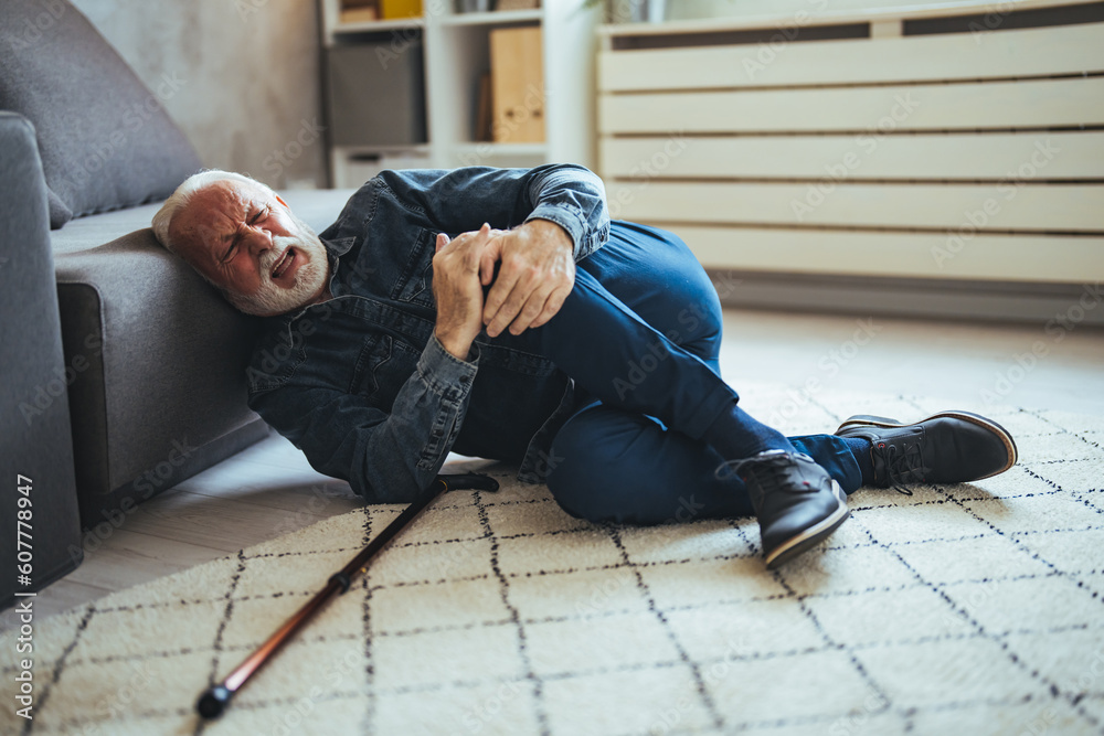 Injured senior male groaning in pain while he tries to get up with a ...