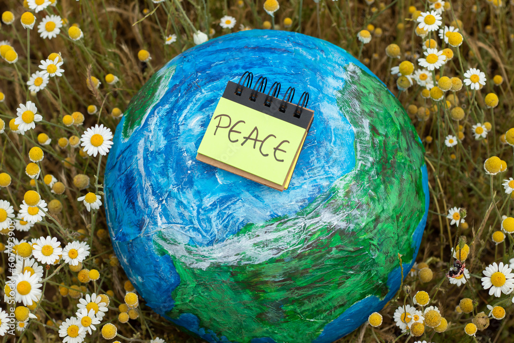 Peace, handwritten word on note placed on earth globe shape in nature ...