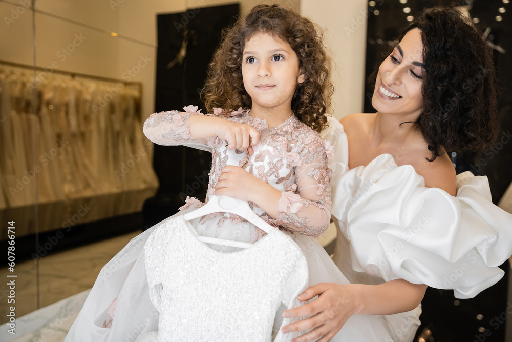 charming middle eastern bride with brunette hair standing in white ...
