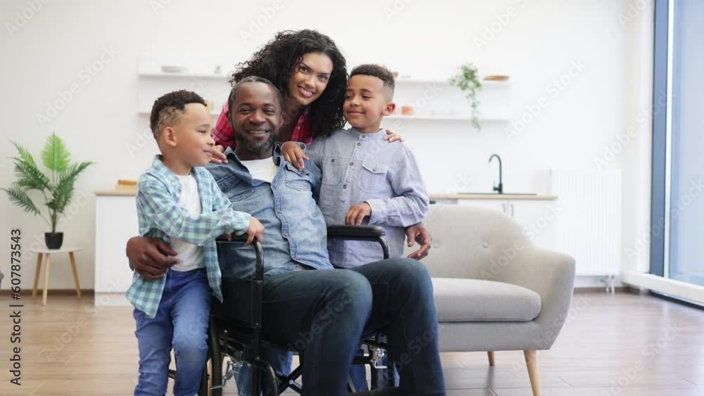 Full length portrait of happy multicultural family of four hugging each ...