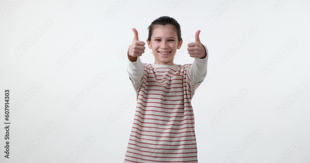 Young boy standing against a white background. The boy is giving a ...