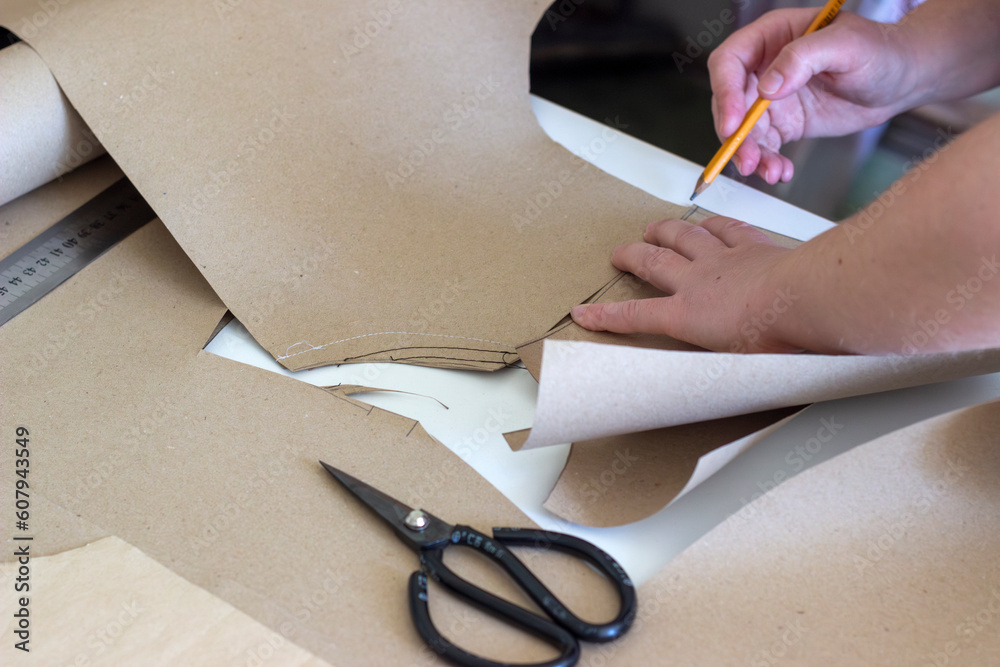 Professional seamstress creates a pattern for clothes in the workshop ...