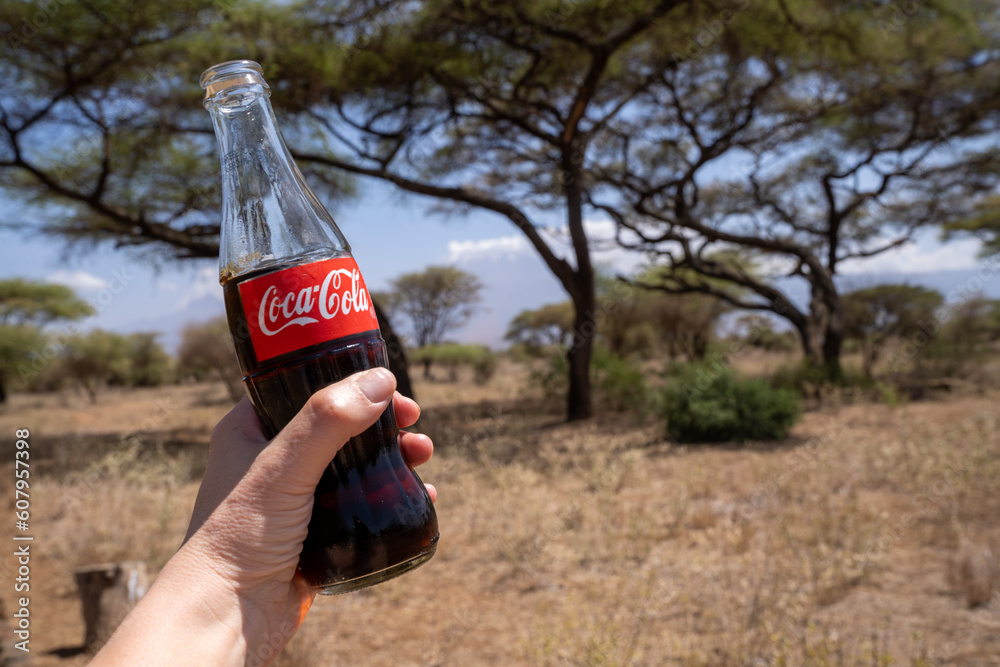 Kenya, Africa - March 5, 2023: Hand holds a glass Coca-Cola coke soda ...
