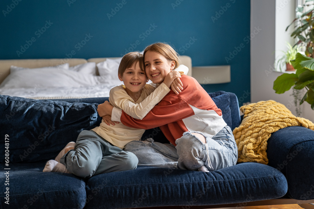 Little kid boy cuddling older sister at home. Happy American siblings ...