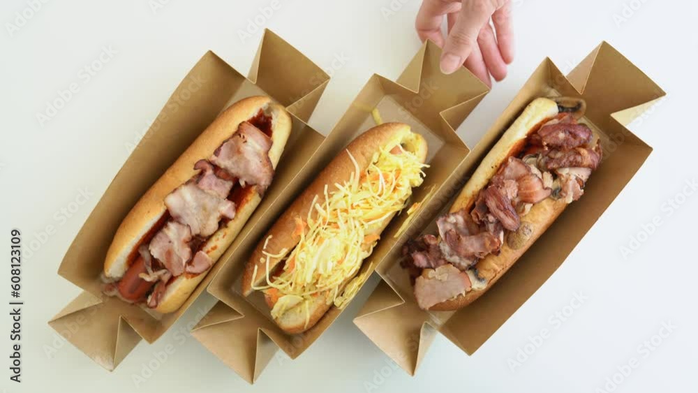 Three various hot dogs in cardboard containers. American fast food with ...
