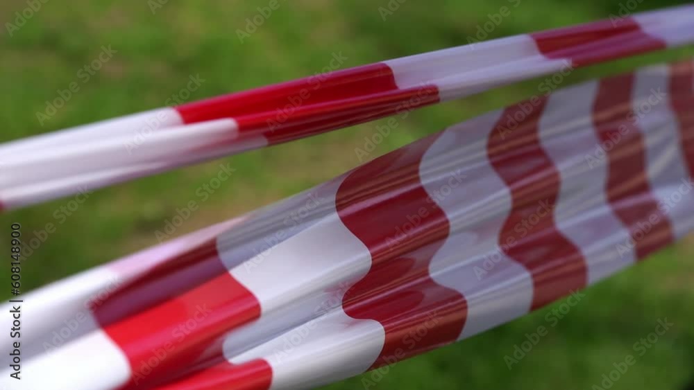 Warning tape with red and white diagonal stripes ripples in the wind ...