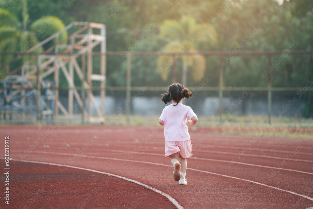 Back side. Baby asian girl run jogging at running track, field at ...