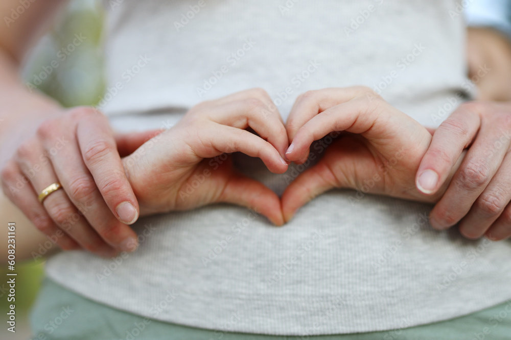Baby hands in a heart symbol on mom's belly, pregnancy and love. Stock ...