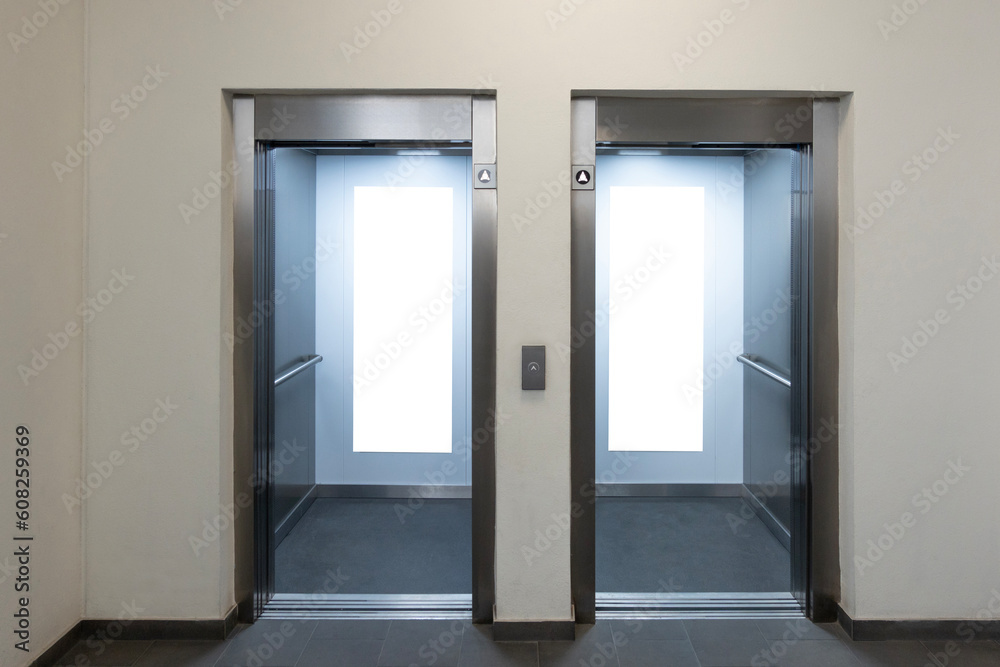 Mock up. Two empty elevators with opened metallic cabins doors and ...