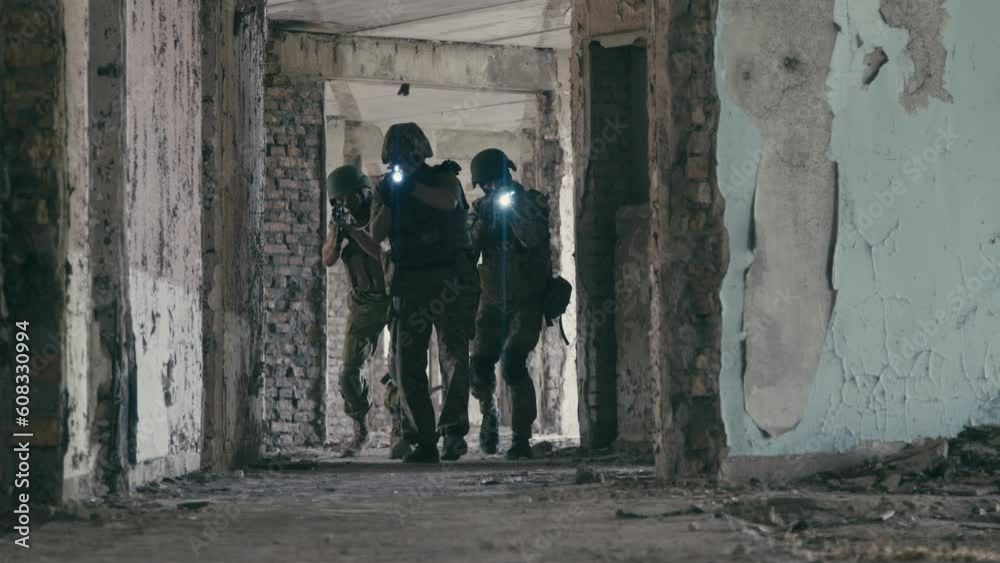 A group of Ukrainian armed military men in masks slowly moves along the ...