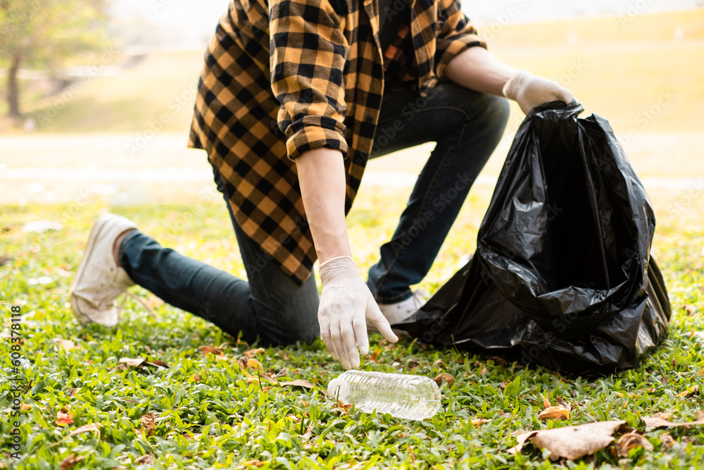 Closeup image of a hand picking up trash on World Environment Day ...