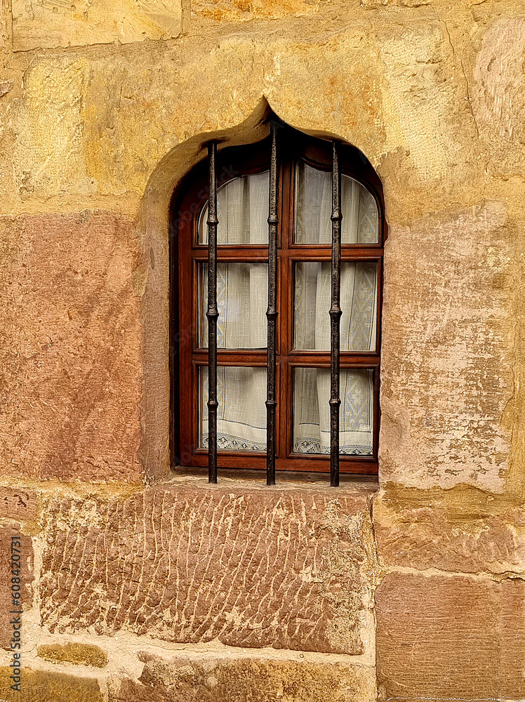A beautiful antique window made of modern materials in a stone wall of ...