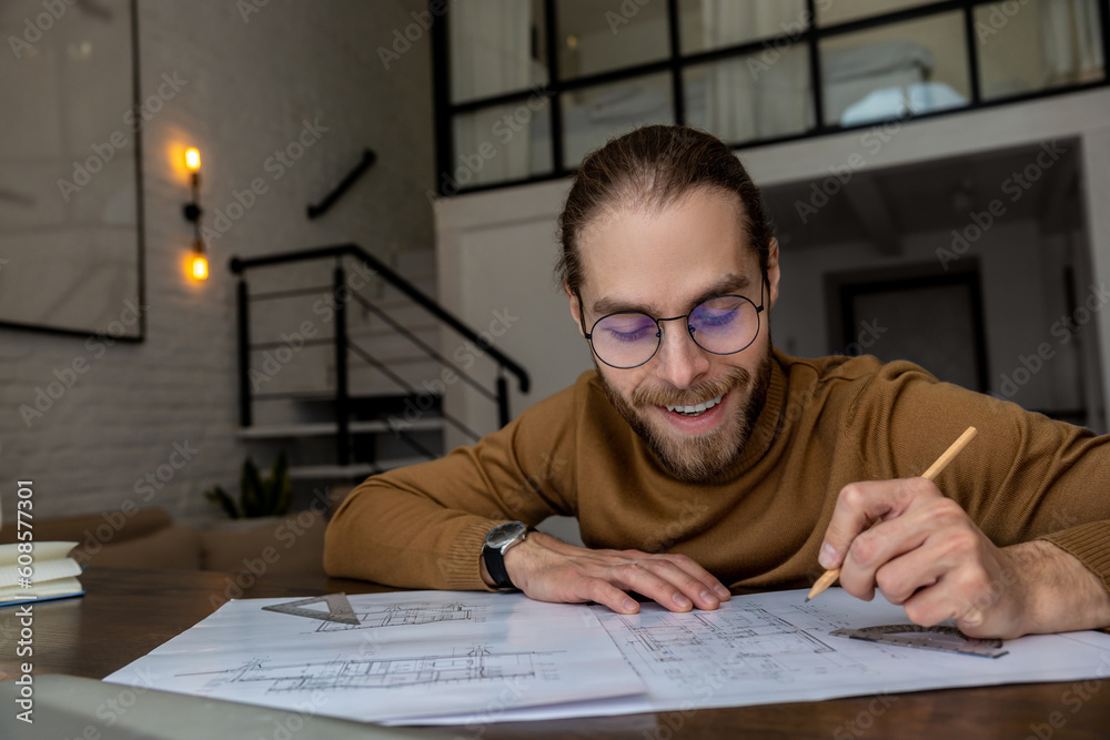 Architect engineer working on blueprints at the office, creatiing new ...