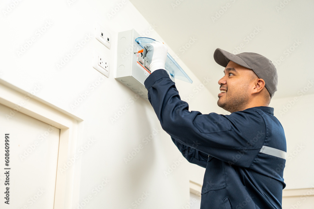 Portrait electrician man in uniform maintenance or fixing switches ...